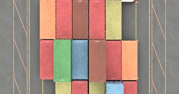 Drone showing multi colored shipping containers stacked in line at sea ...