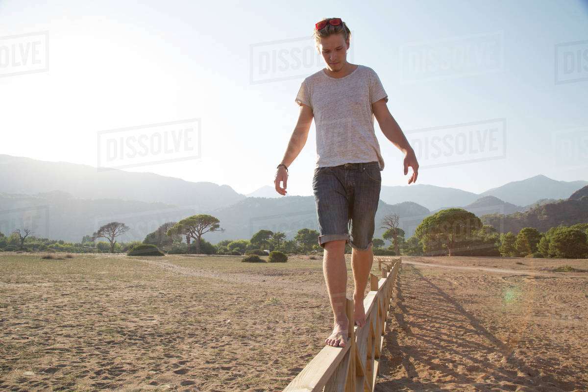 Man balancing on a wooden fence - Royalty-free Stock Photo | Dissolve