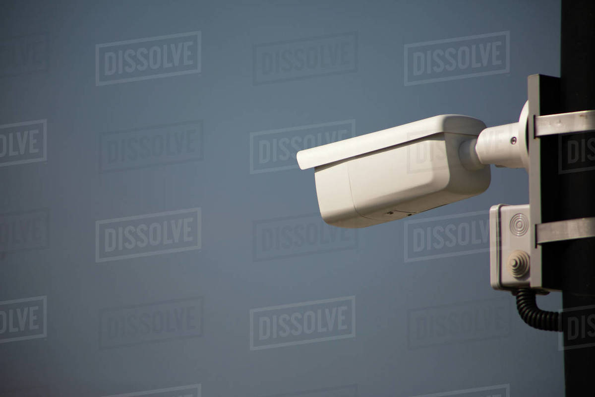 Outdoor surveillance camera on a pole in the park on a blurred ...