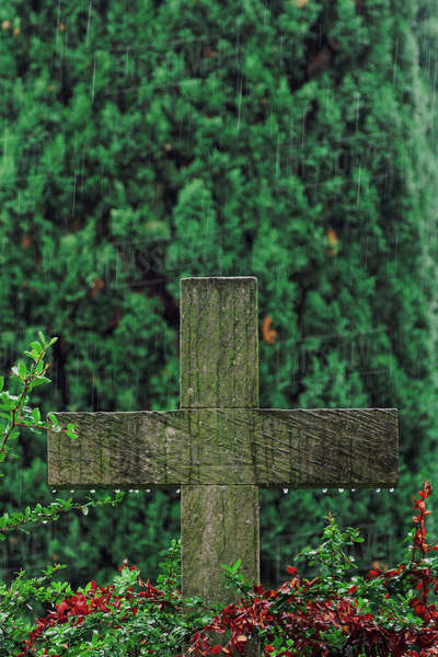 Christian cross on cemetery with water droplets under heavy rain ...