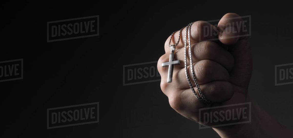 Silver crucifix or cross pendant and necklace on body or hand studio ...