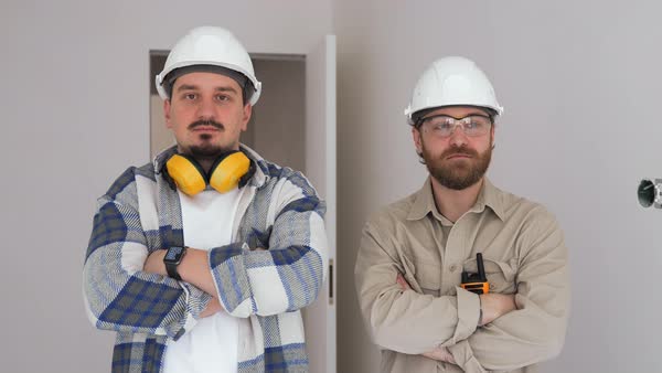 Two self-confident main builders look into the frame with a calm look ...