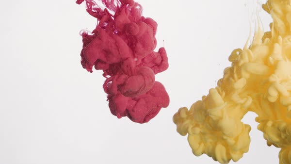 Yellow and red paint dissolving abstract on white background. Slow ...