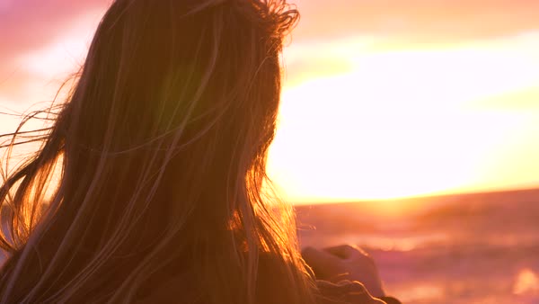 Young female photographer looking at the beautiful evening sun and the ...