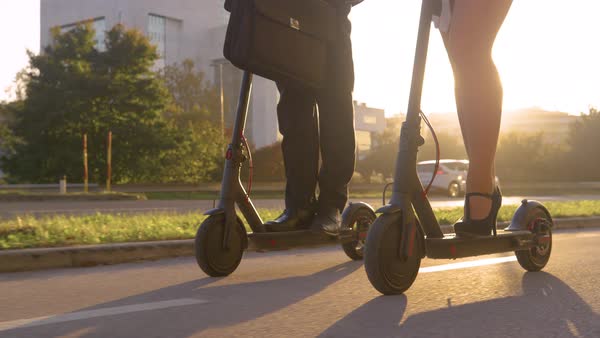 Business people riding electric scooters on street in city - 4K Royalty ...