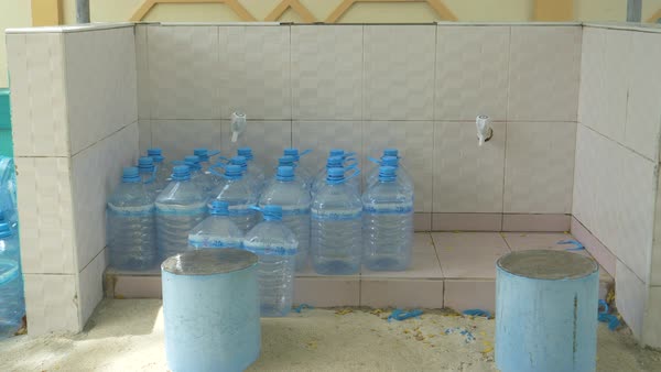 CLOSE UP: Empty gallon bottles are orderly organized as locals wait for ...