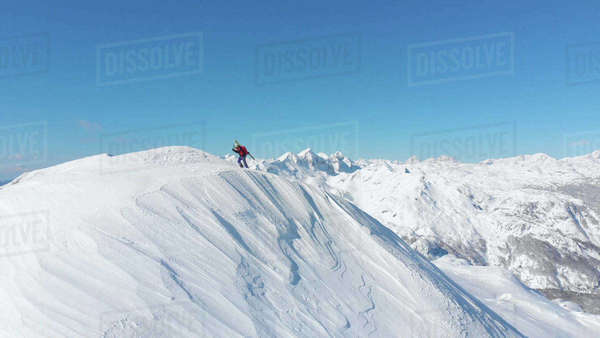 AERIAL: Flying along the snowy mountain ridge being scaled by unknown ...