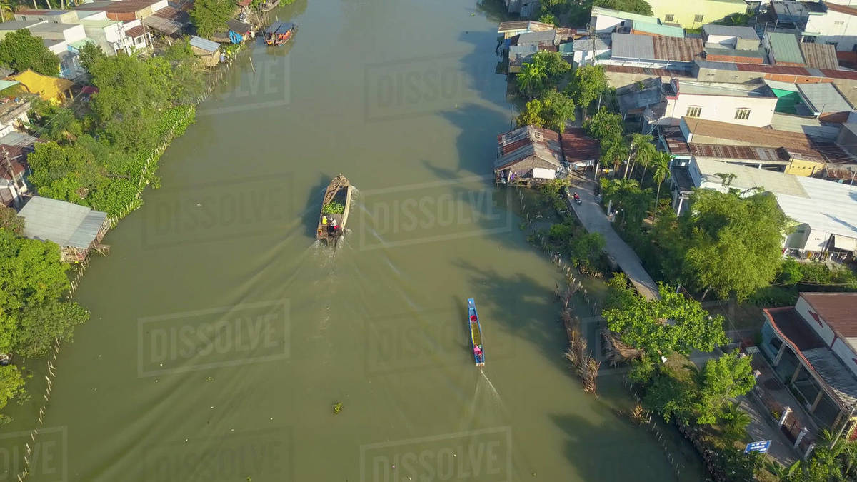 DRONE: Flying behind two wooden boats cruising past waterfront houses ...