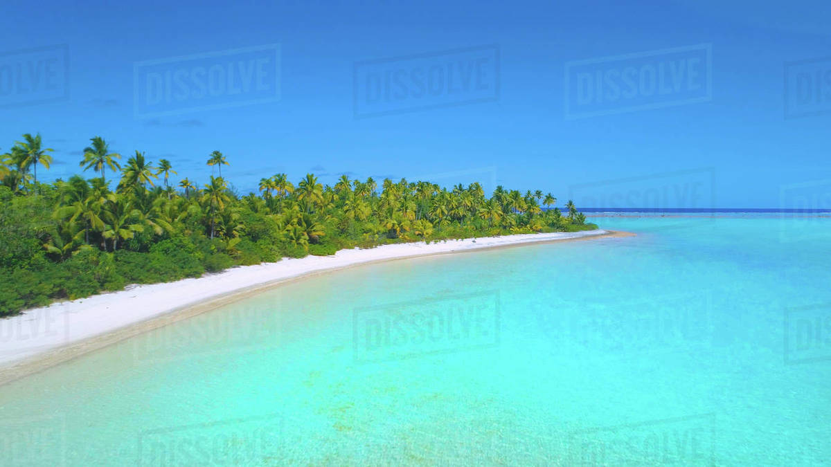 AERIAL: Flying over the tranquil shallow ocean water by the pristine ...