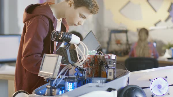 Boy works on a fully functional programable robot with bright led ...