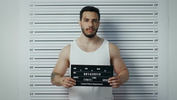 In a police station arrested beaten man poses for side, front view ...