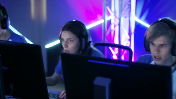 Moving Shot of Team of Boys and Girls Gamers Playing in Multiplayer PC ...