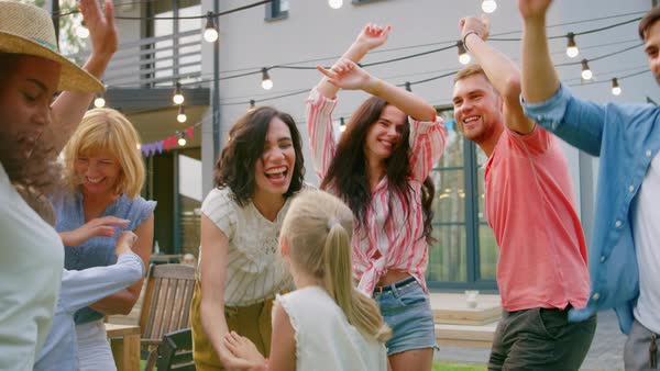 Family and Friends Dancing together at the Garden Party Celebration ...