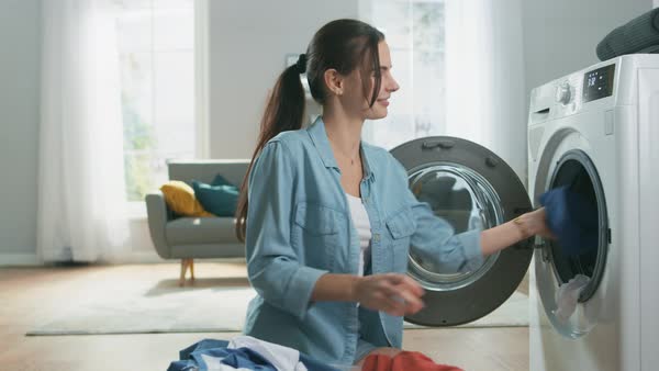 Beautiful Smiling Brunette Young Woman Sits in Front of a Washing ...