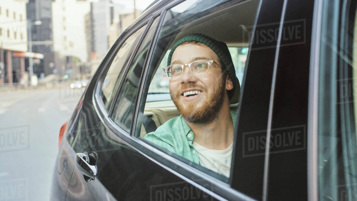 Stylish Young Man Rides on a Passenger Back Seat of a Car, Looks out of ...