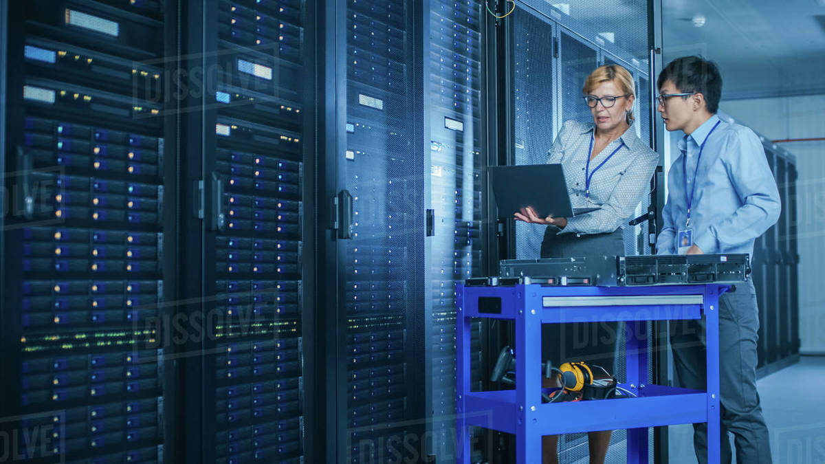 In the Modern Data Center: Engineer and IT Specialist Work with Server ...