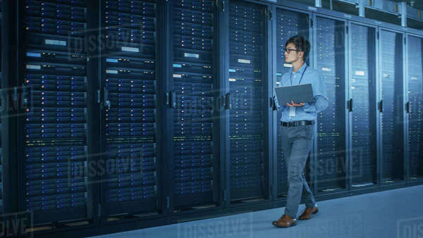 In the Modern Data Center: IT Engineer Working with Server Racks, Uses ...