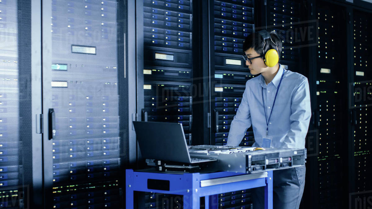 In the Modern Data Center: IT Engineer Doing Maintenance and ...