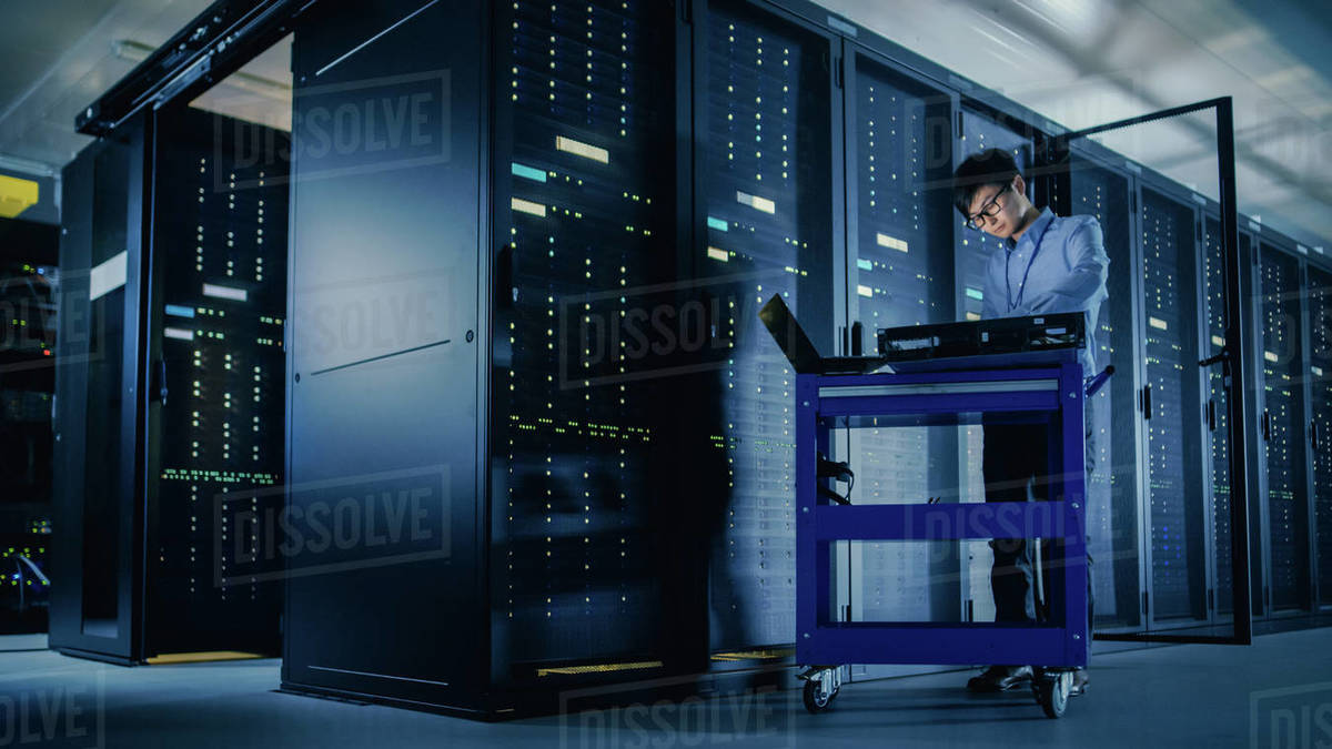 In Data Center: Male IT Technician Running Maintenance Programme on a ...