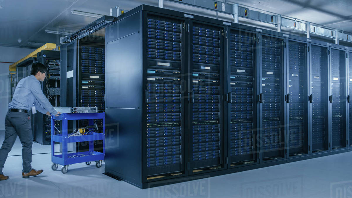 In the Modern Data Center: Team of IT Technicians Working with Server ...