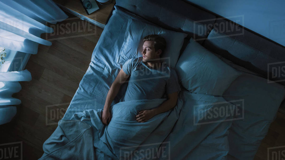 Top View of Handsome Young Man Sleeping Cozily on a Bed in His Bedroom ...