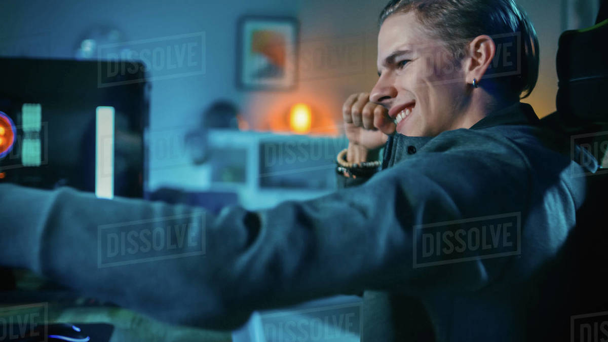 Joyful gamer playing and winning in first-person shooter online video ...