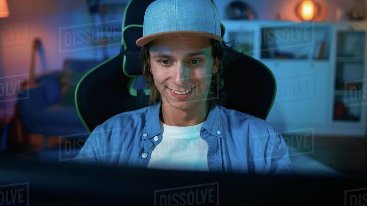 Handsome surprised and excited young man watching an action video on a ...