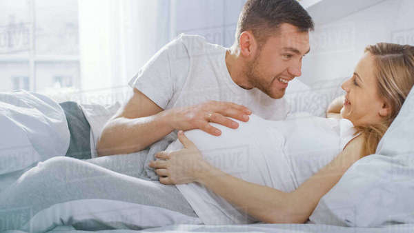 Happy Young Couple Cuddling Together in the Bed, Young Woman is ...