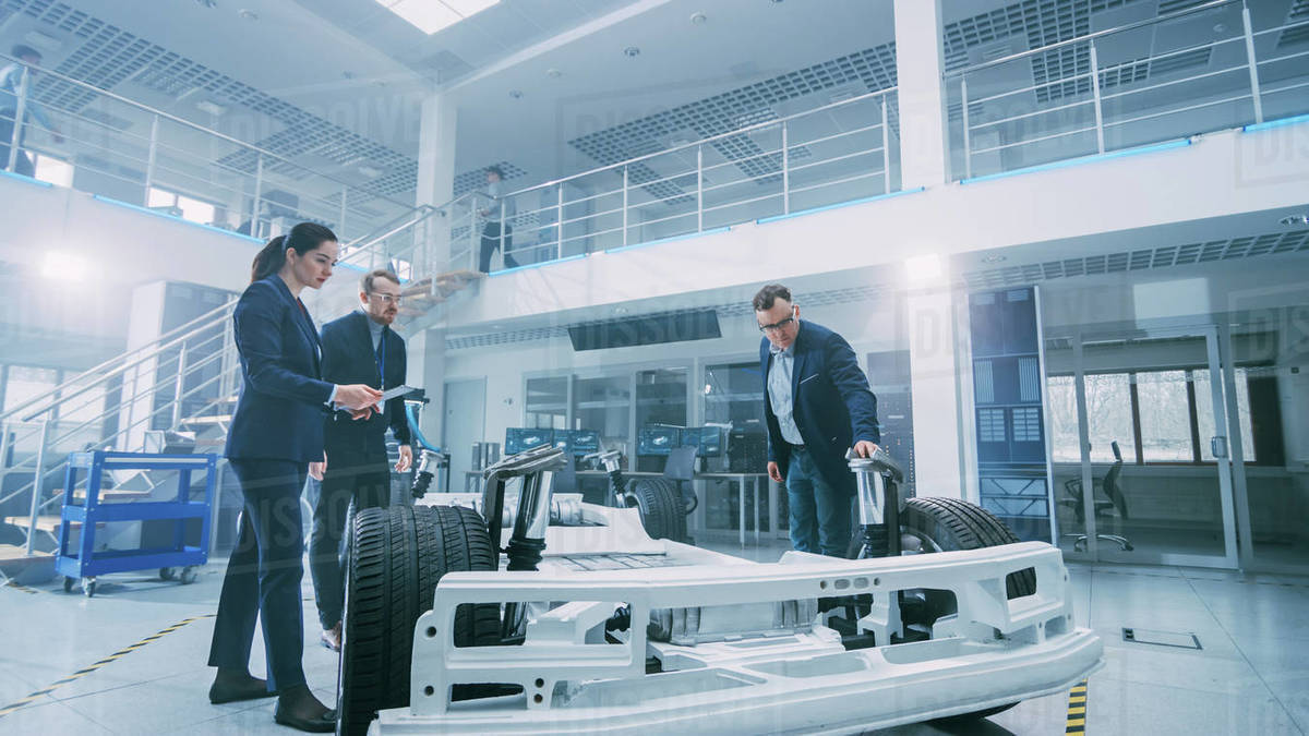 Automotive Design Engineers Talking while Working on Electric Car ...