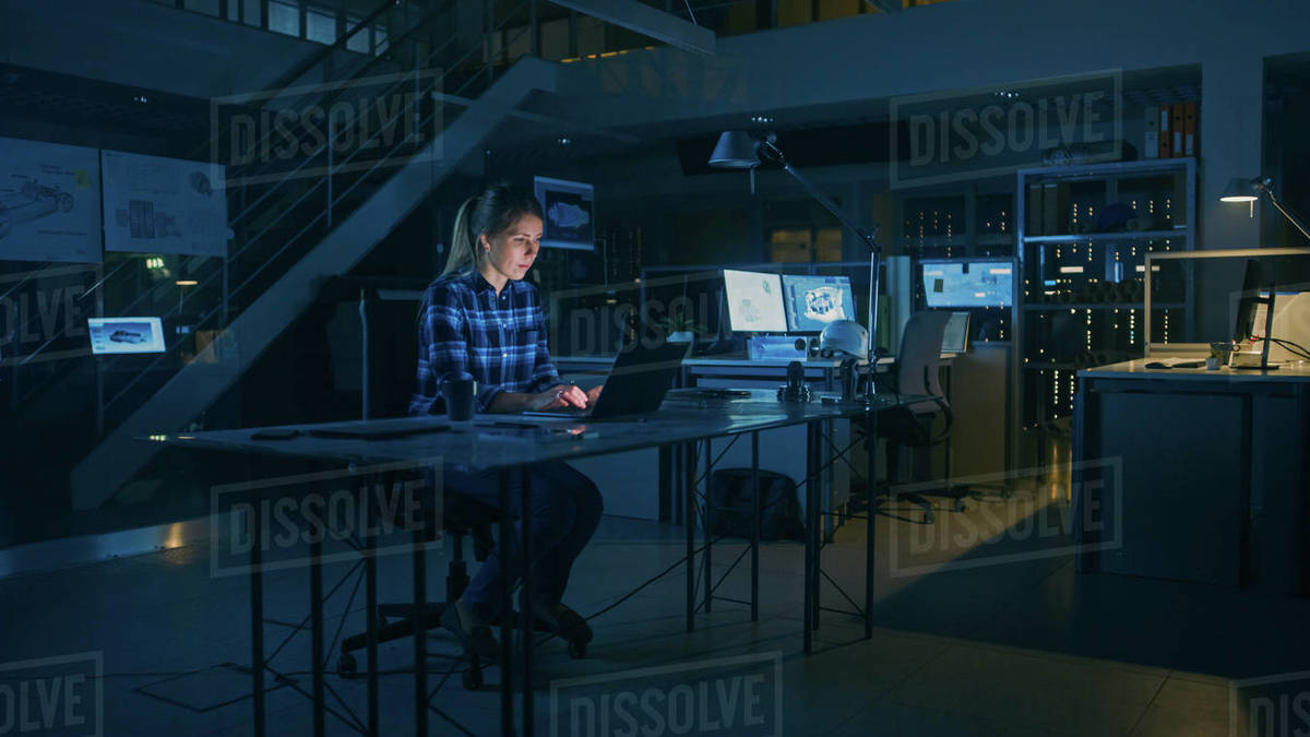 Beautiful Female Engineer Sitting at Her Desk Works on a Laptop ...
