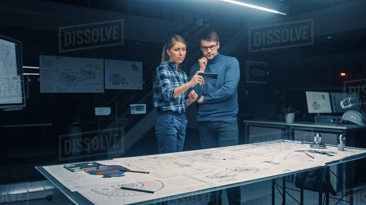 Two Young Software Development Engineers Talk and Use Smartphone with ...