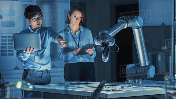 Man and Woman Engineers with Laptop and a Tablet Analyse and Discuss ...