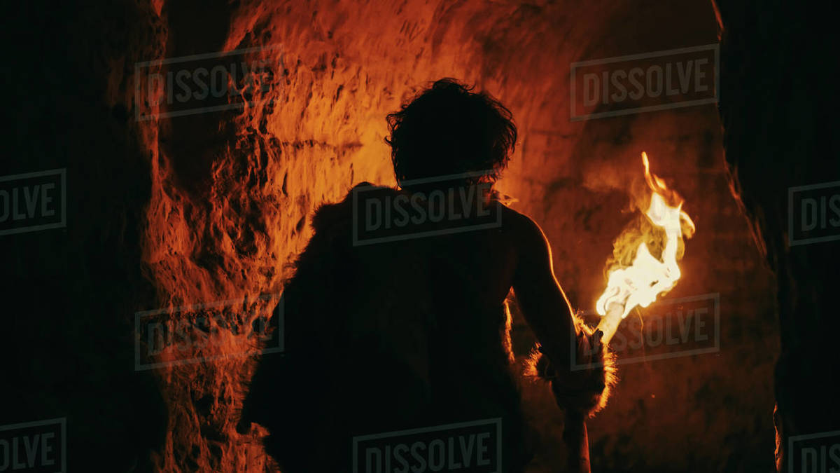 Primeval Caveman Wearing Animal Skin Exploring Cave At Night Holding ...
