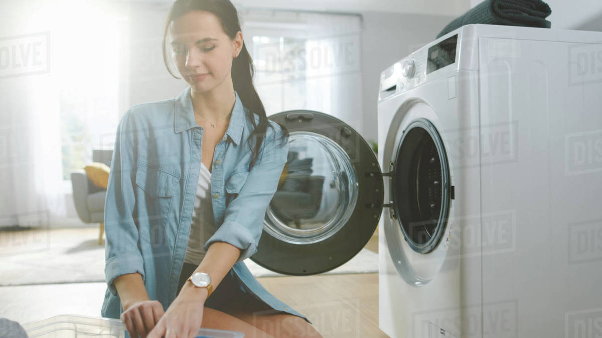 Beautiful Smiling Brunette Young Woman Sits in Front of a Washing ...