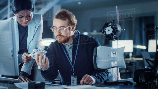 Electronics Development Engineer Working at His Desk, Demonstrates ...