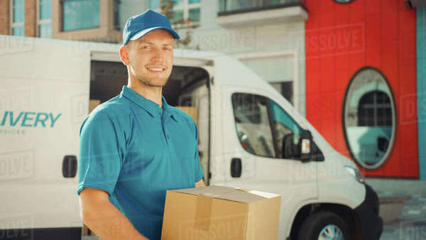 Handsome Courier Takes Cardboard Box Package out of Delivery Van Walks ...