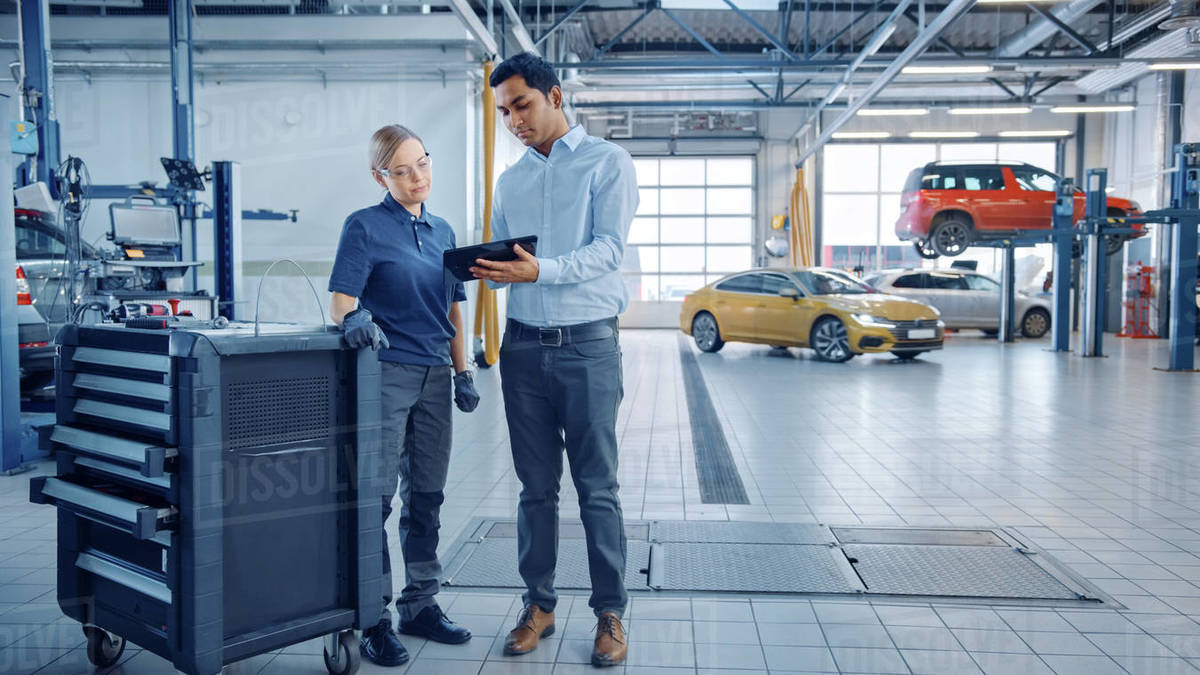 Car Service Manager and a Confident Female Mechanic Talk About Work ...