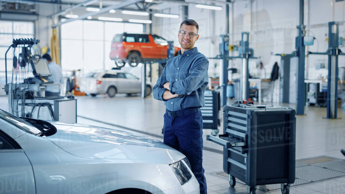 Handsome Car Mechanic is Posing in a Car Service. He Wears a Jeans ...
