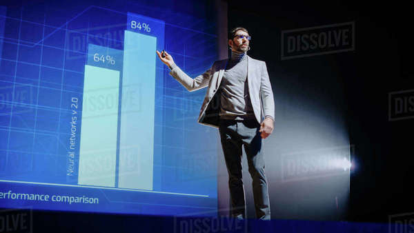 On-Stage Speaker Gives Presentation of Technological Device, Shows ...