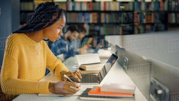University Library: Gifted Girl uses Laptop, Writes Notes for the Paper ...