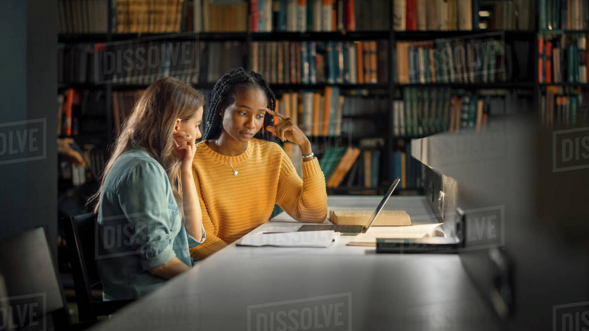 University Library: Two Gifted Girl Students Study, Use Laptop Computer ...