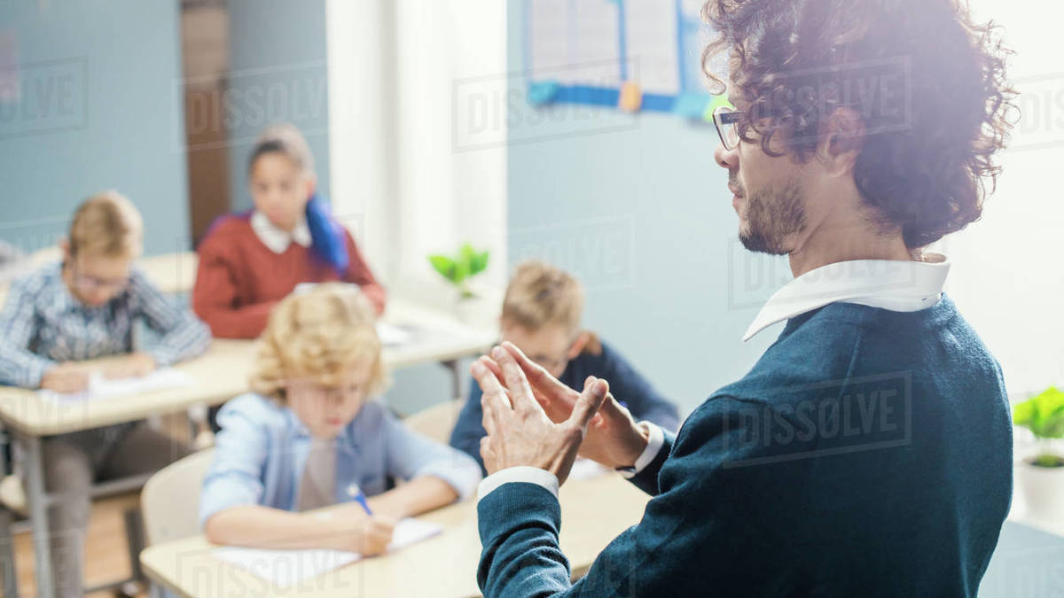 Over the Soulder Shot of Teacher Explaining Lesson to Classroom Full of ...