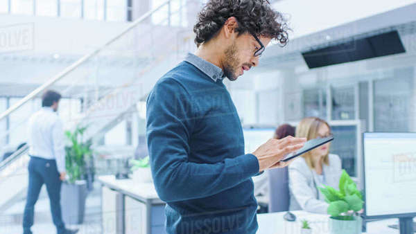 In Bright Modern Office: Beautiful Office Worker is Standing and Using ...