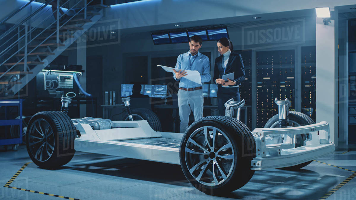 Auto Industry Design Facility: Male Chief Engineer Shows Car Blueprints ...
