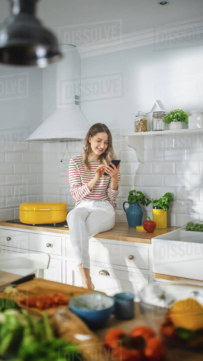 Beautiful Young Female in Striped Jumper and White Pants is Sitting on ...