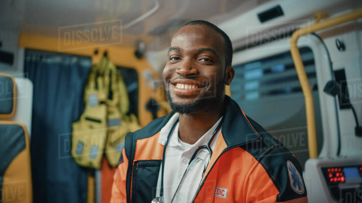 Paramedic Smiles and Poses for Camera in an Ambulance - Royalty-free ...