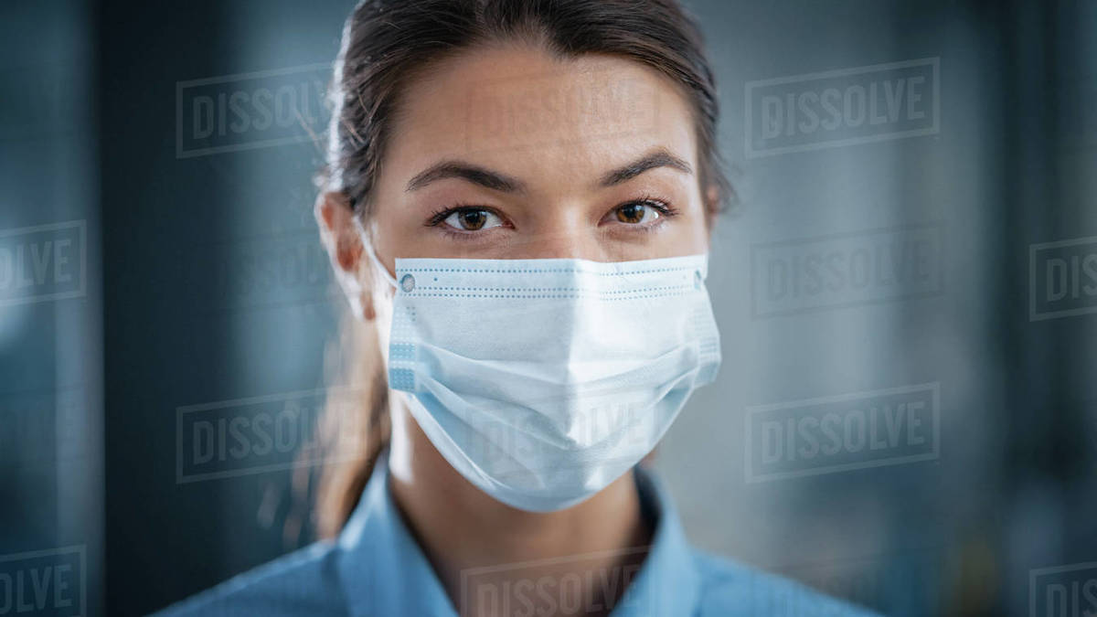 Female Wearing a Disposable Protective Face Mask - Stock Photo - Dissolve