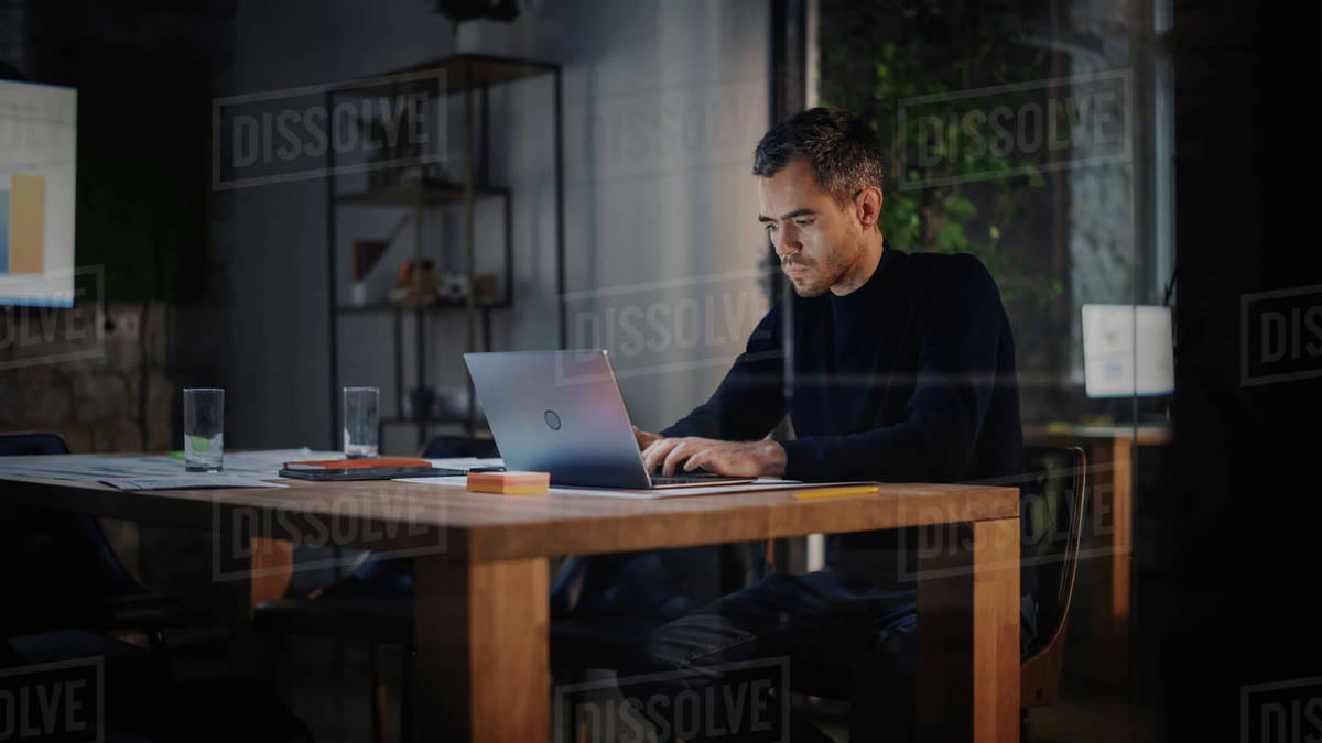 Male is Working on Laptop Computer while Sitting Behind a Conference ...