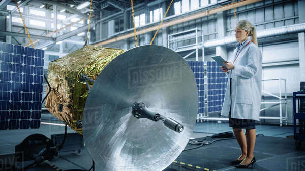 Female Engineer Uses Digital Tablet Computer while Working on Satellite ...
