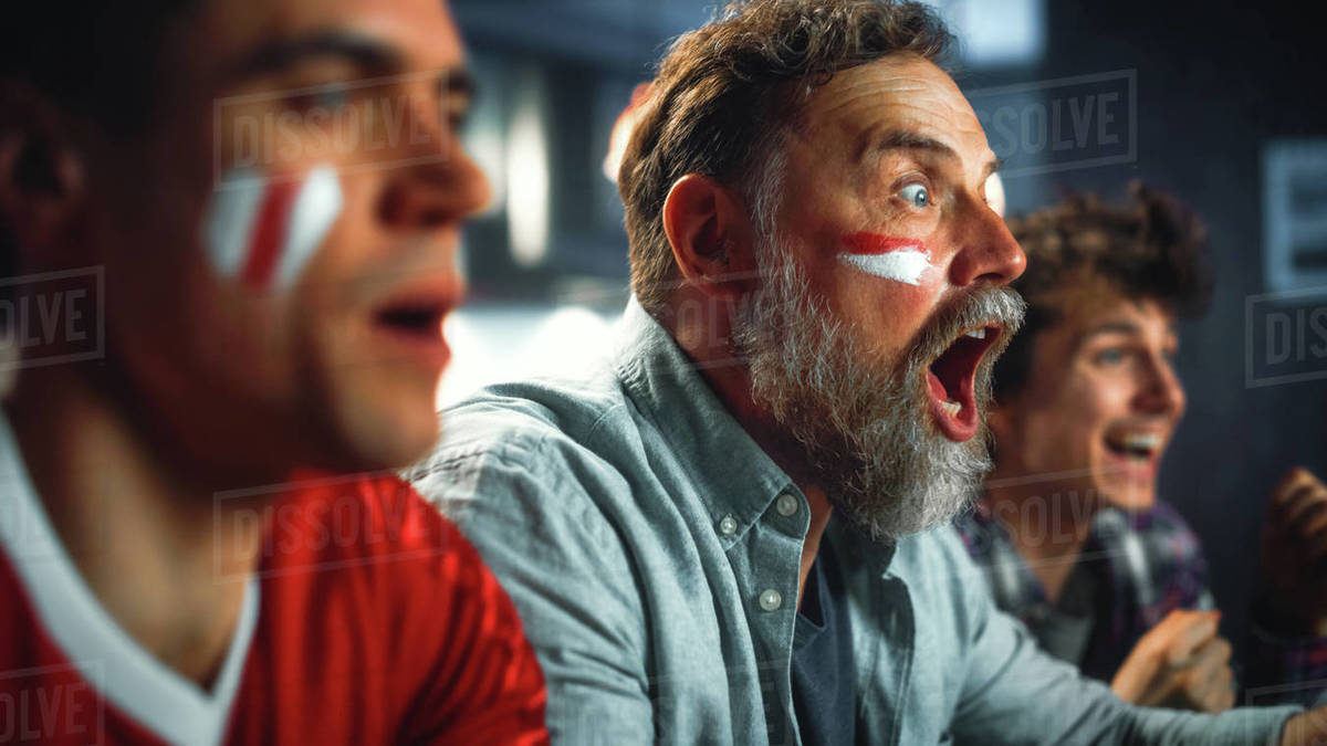 At Home Three Joyful Sports Fans with Painted Faces Sitting on a Couch ...